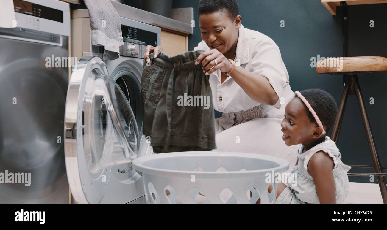 Laundry, mother and child helping with folding of clothes together in a ...