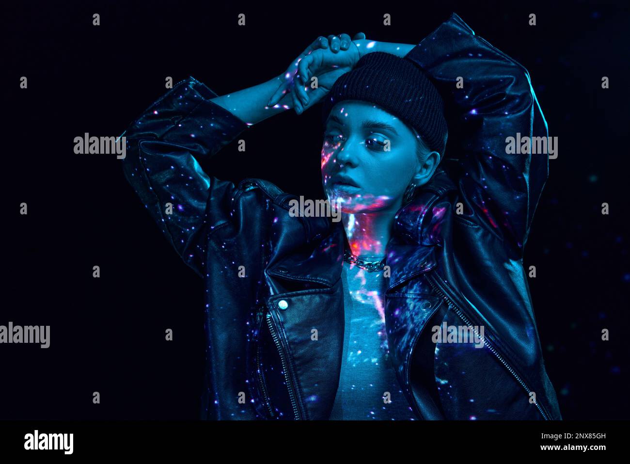 Portrait of young blonde girl with neon space holographic projection on ...