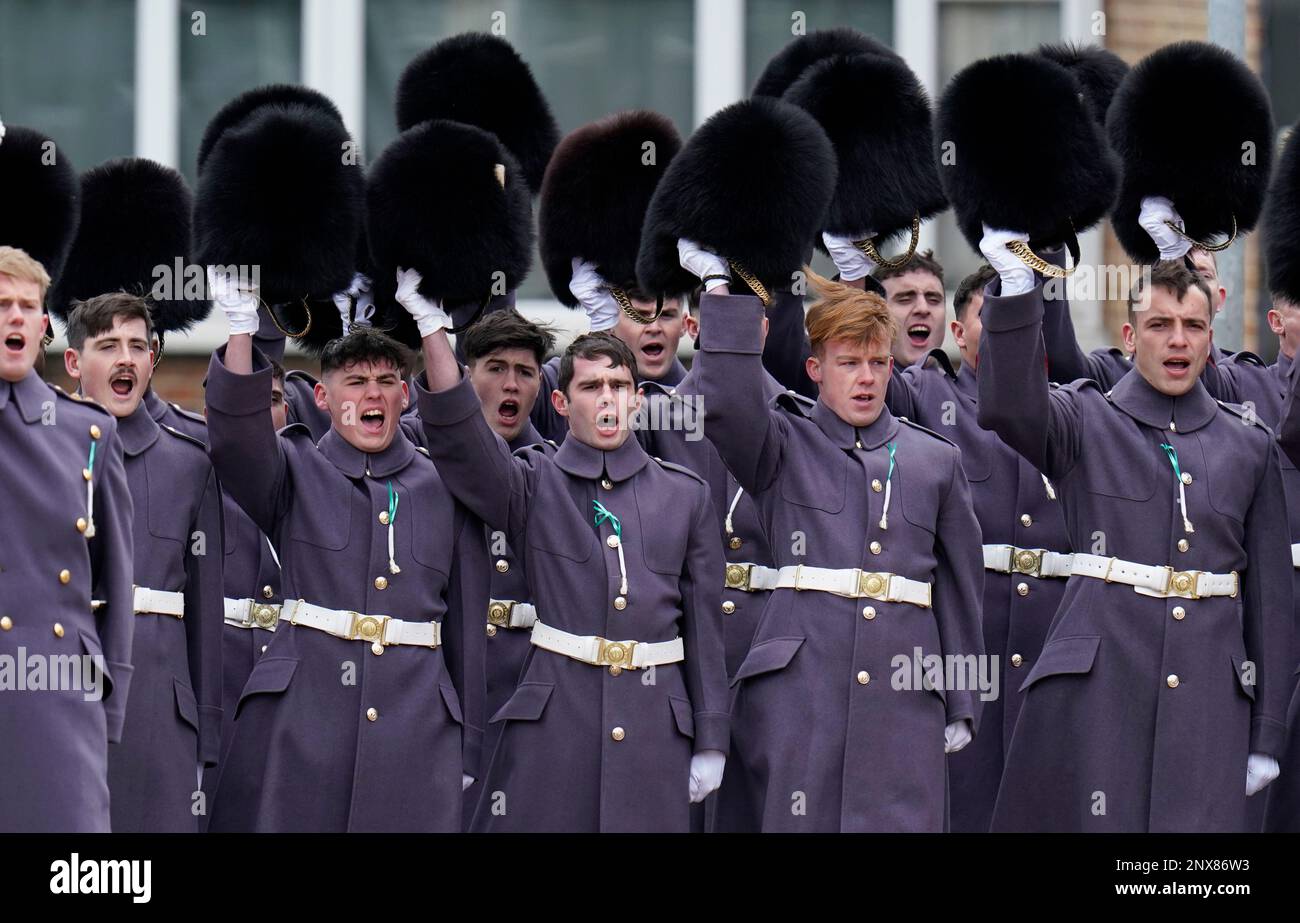 Members of the Welsh Guards raise their bearskin headress as they give ...