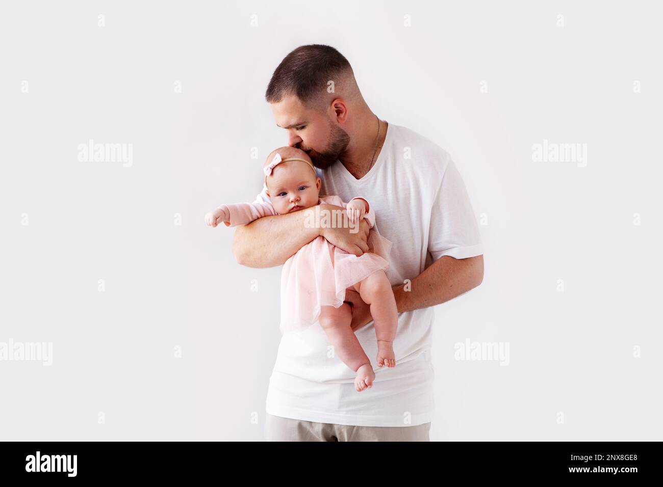 Portrait father holding his newborn baby girl on white background. Dad ...