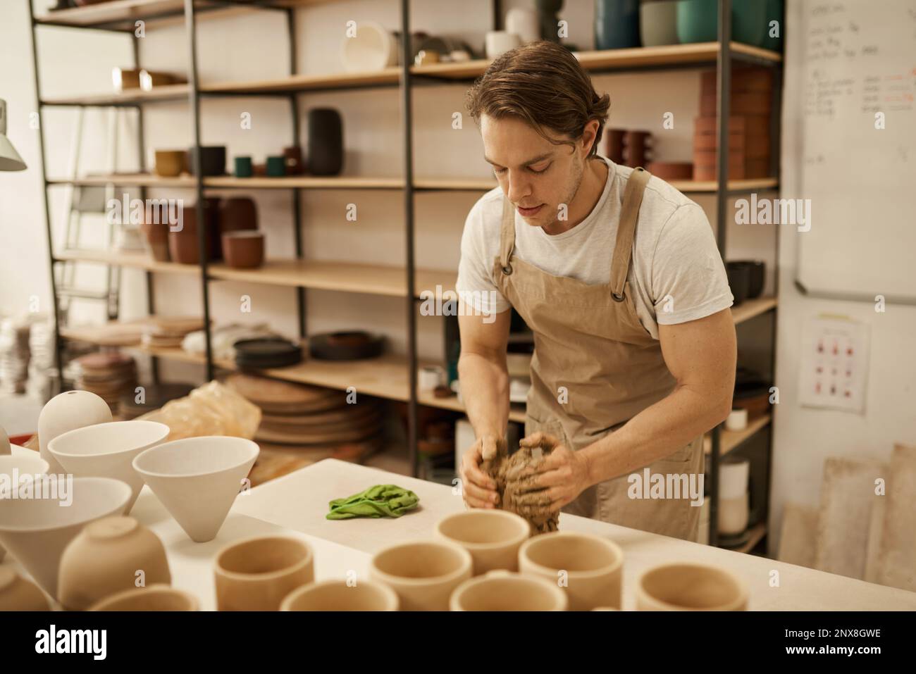 ceramist shaping clay at a table in a ceramic studio Stock Photo - Alamy