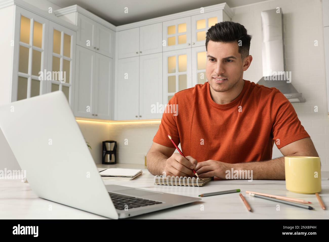 Man drawing in notebook at online lesson indoors. Distance learning ...