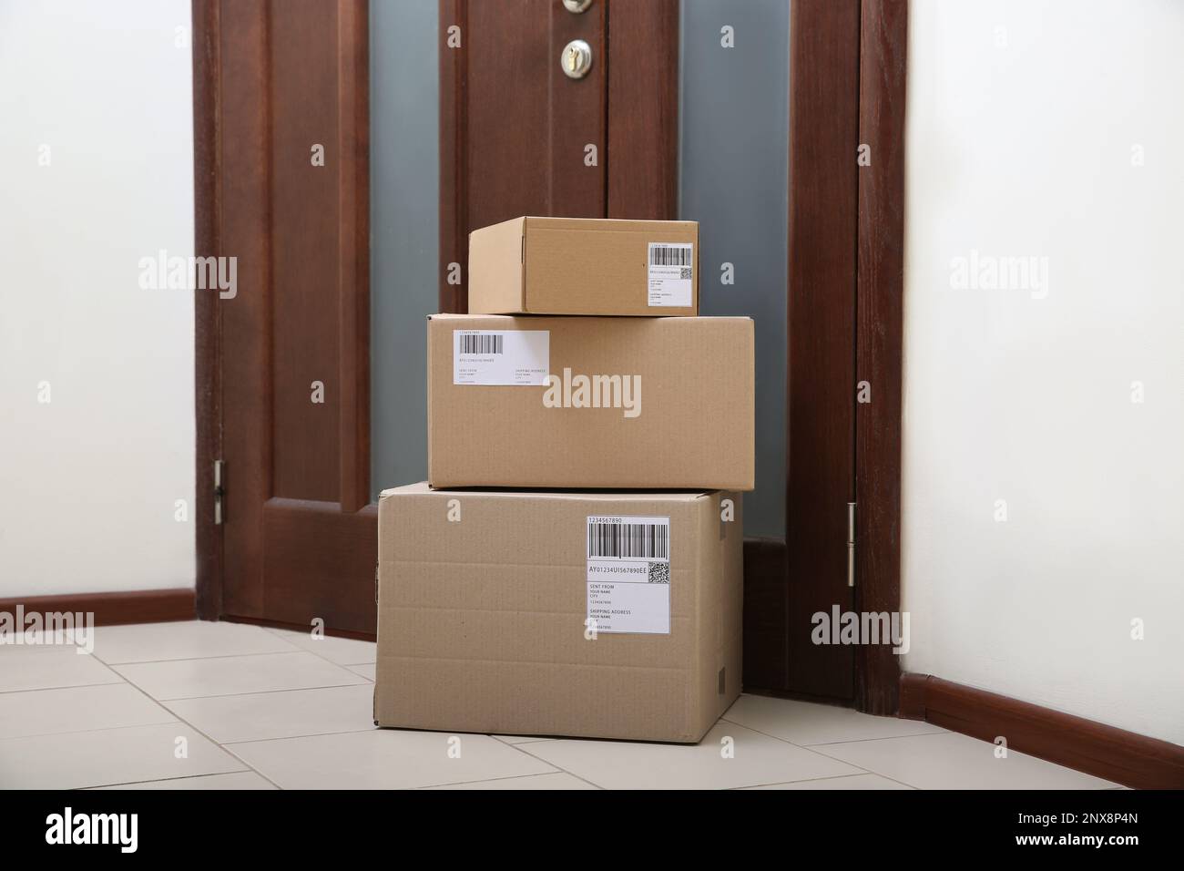 Stacked parcels near door on floor. Delivery service Stock Photo - Alamy