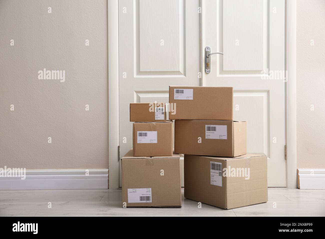 Stacked parcels near door on floor, space for text. Delivery service ...