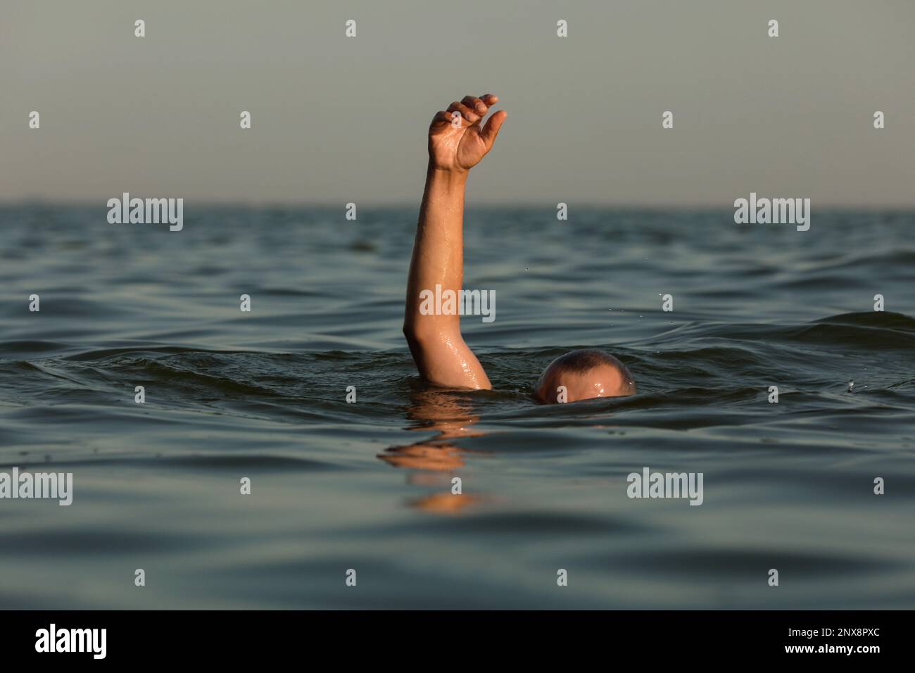 Drowning man reaching for help in sea Stock Photo - Alamy
