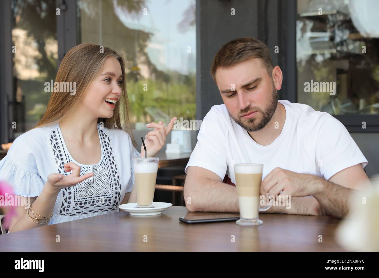 Young man having boring date with talkative girl in outdoor cafe Stock ...