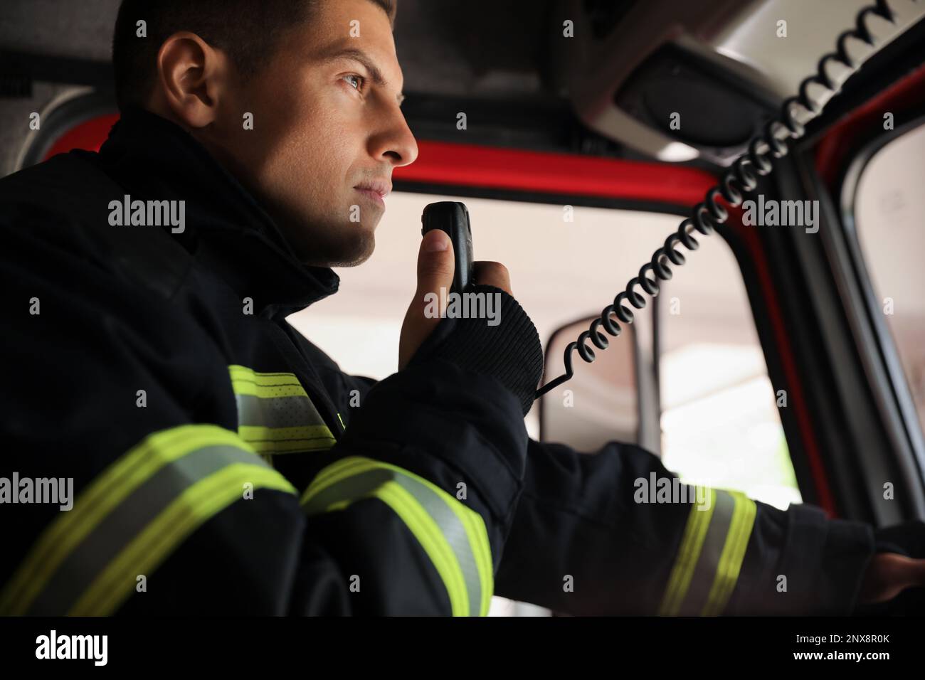 Firefighter using radio set while driving fire truck, closeup Stock ...