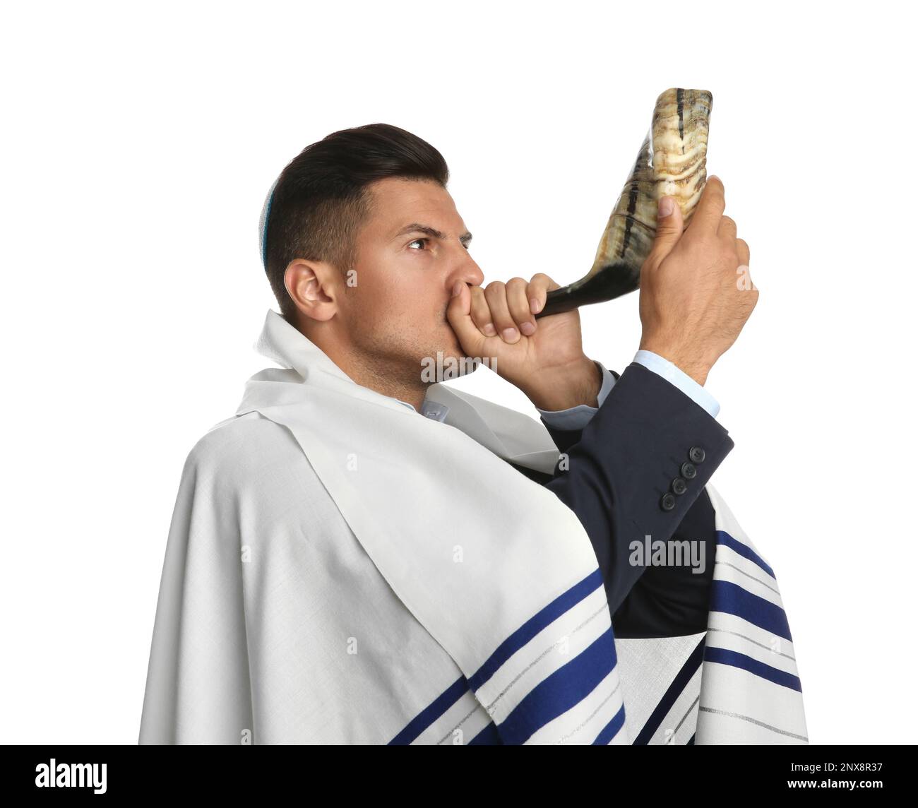 Jewish man with kippah and tallit blowing shofar on white background ...
