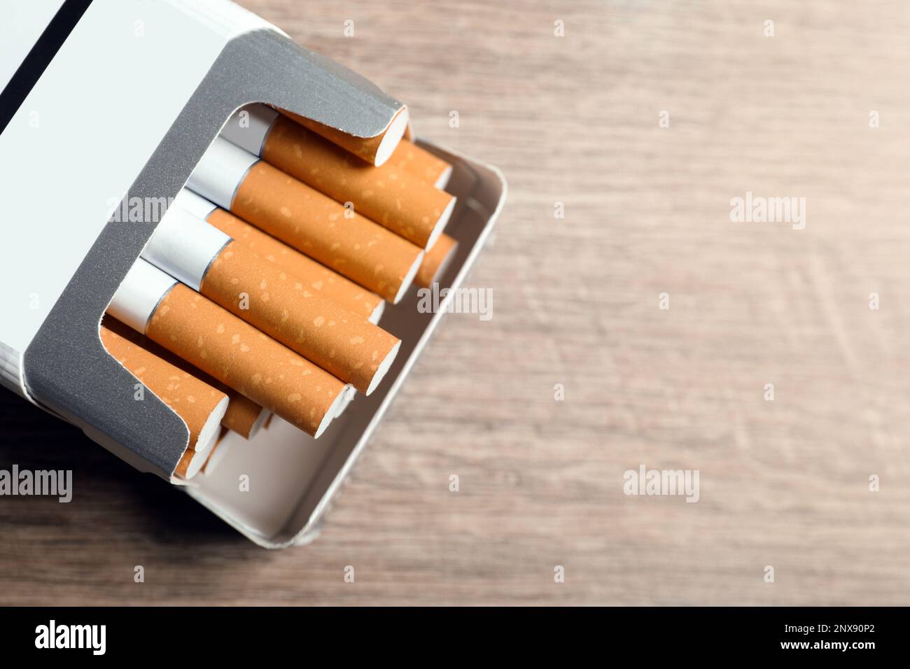 Cigarettes in pack on wooden table, top view. Space for text Stock ...