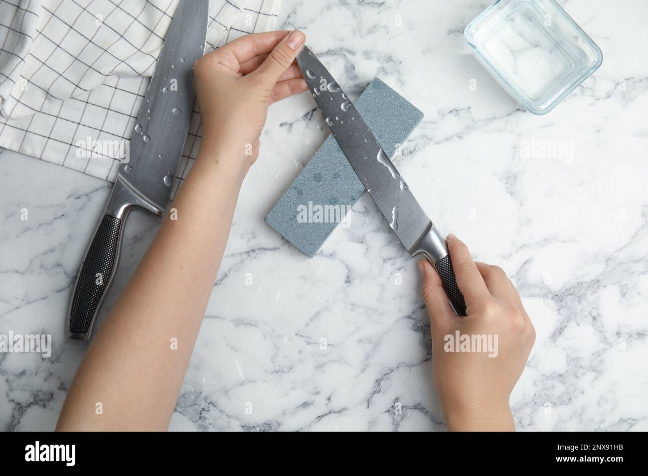 Woman sharpening knife at white marble table, top view Stock Photo - Alamy