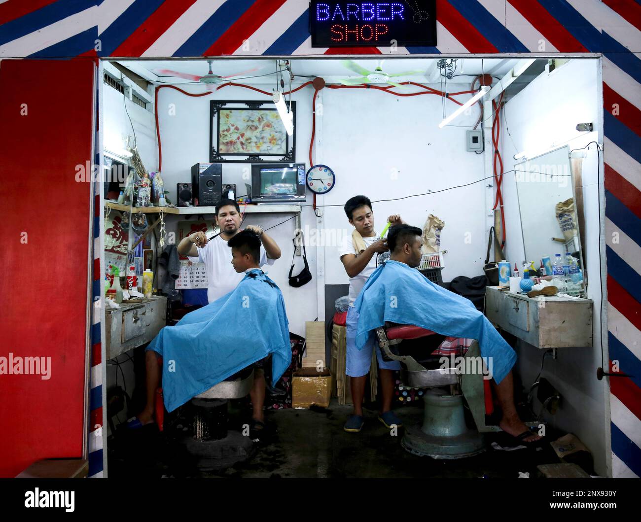 Filipino men get a haircut inside a barber shop near the Balintawak ...