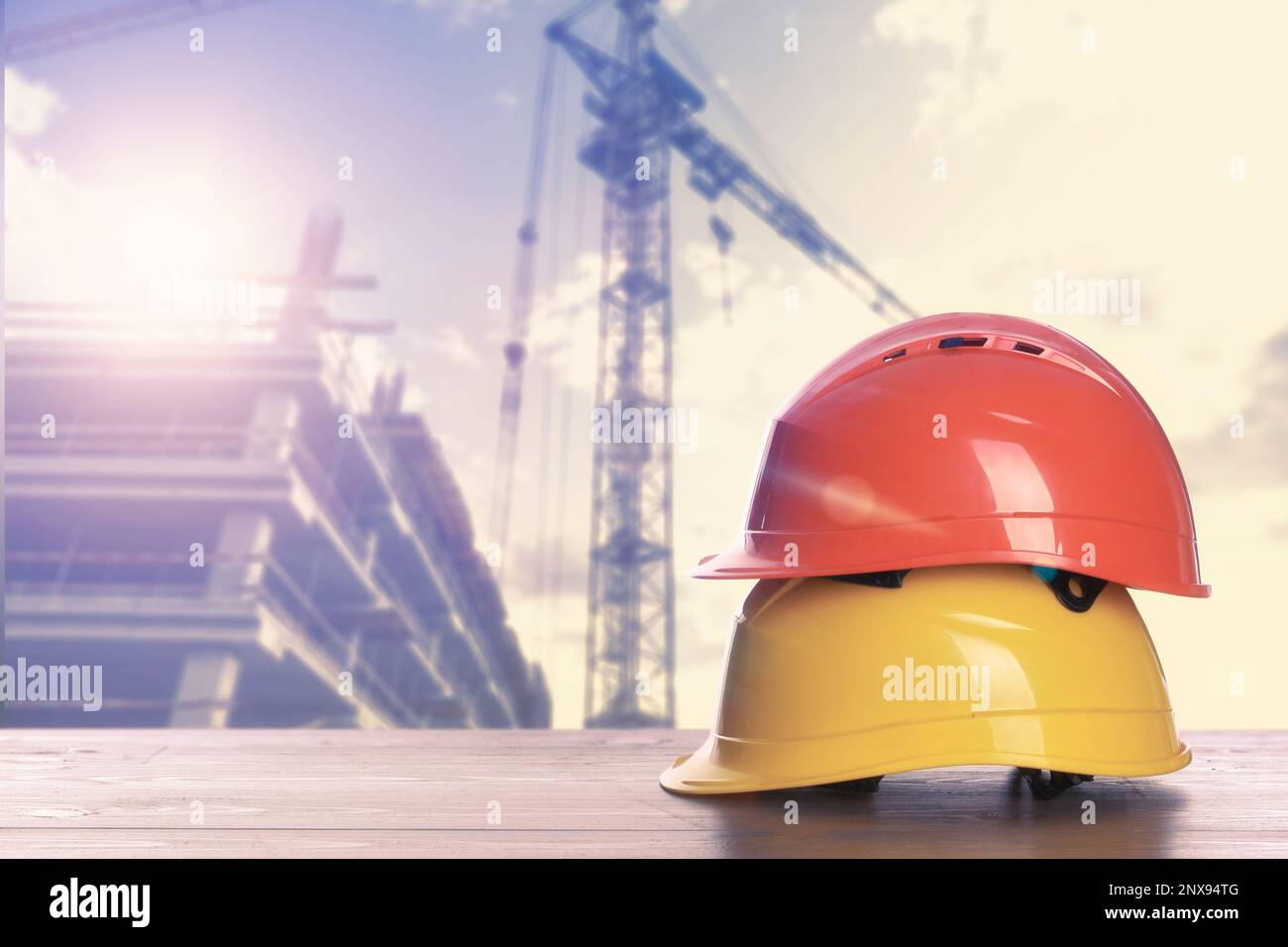 Hard hats on wooden surface at construction site with unfinished ...