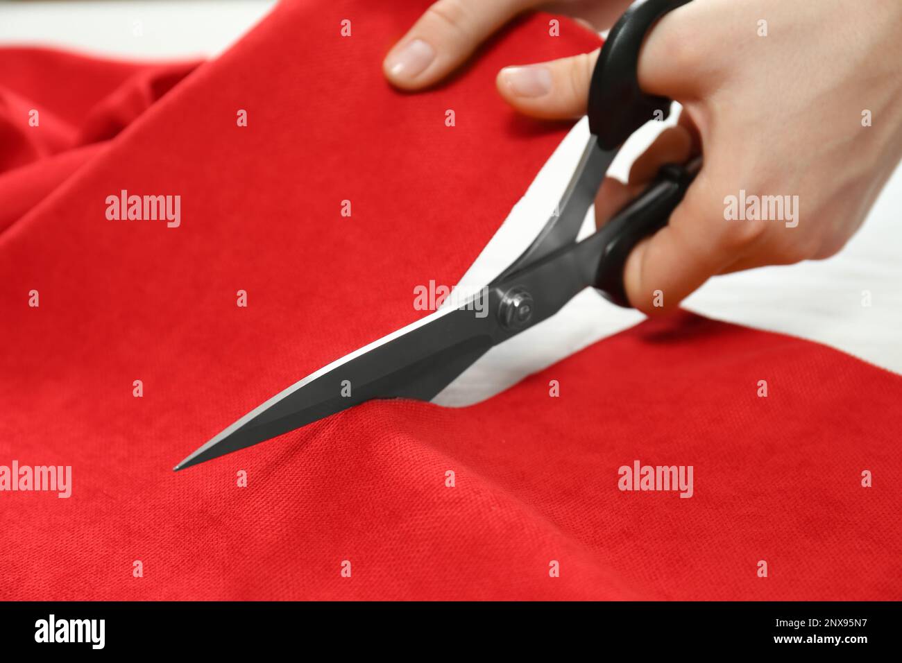 Seamstress cutting red fabric with scissors at workplace, closeup Stock ...