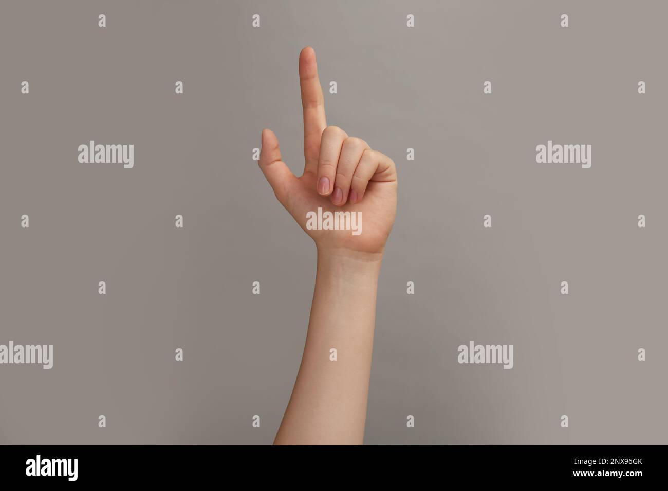 Woman showing index finger on grey background, closeup Stock Photo - Alamy
