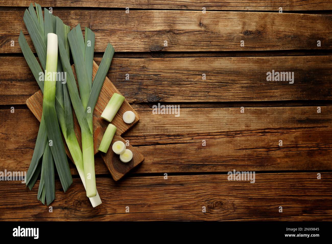 Fresh raw leeks on wooden table, top view. Space for text Stock Photo ...