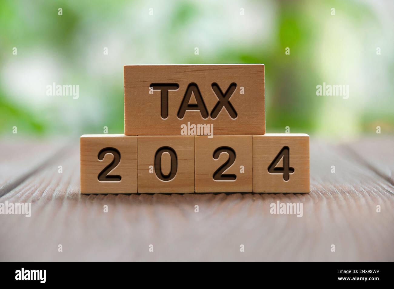Tax 2024 text on wooded blocks with blurred nature background. Taxation ...