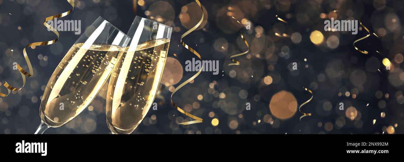 Glasses with sparkling wine and shiny serpentine streamers against ...