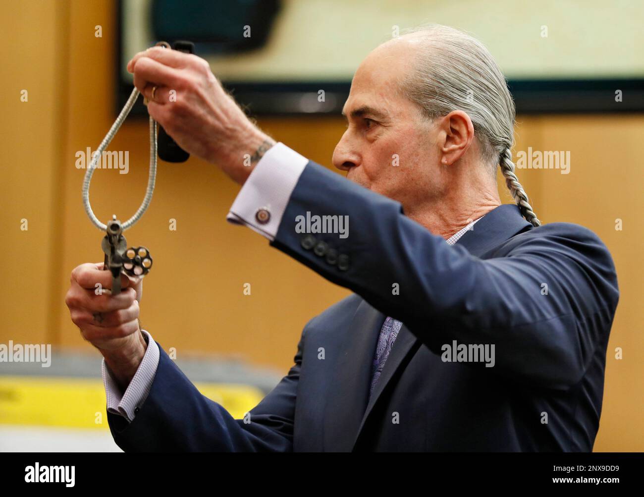 Defense attorney Bruce Harvey shows the gun that Tex McIver used during ...
