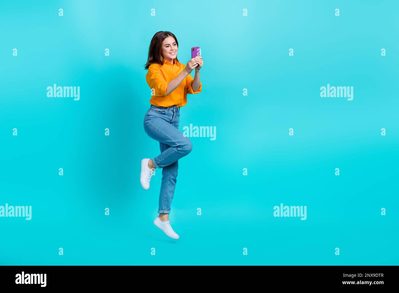 Full length photo of confident pretty lady wear orange shirt jumping ...