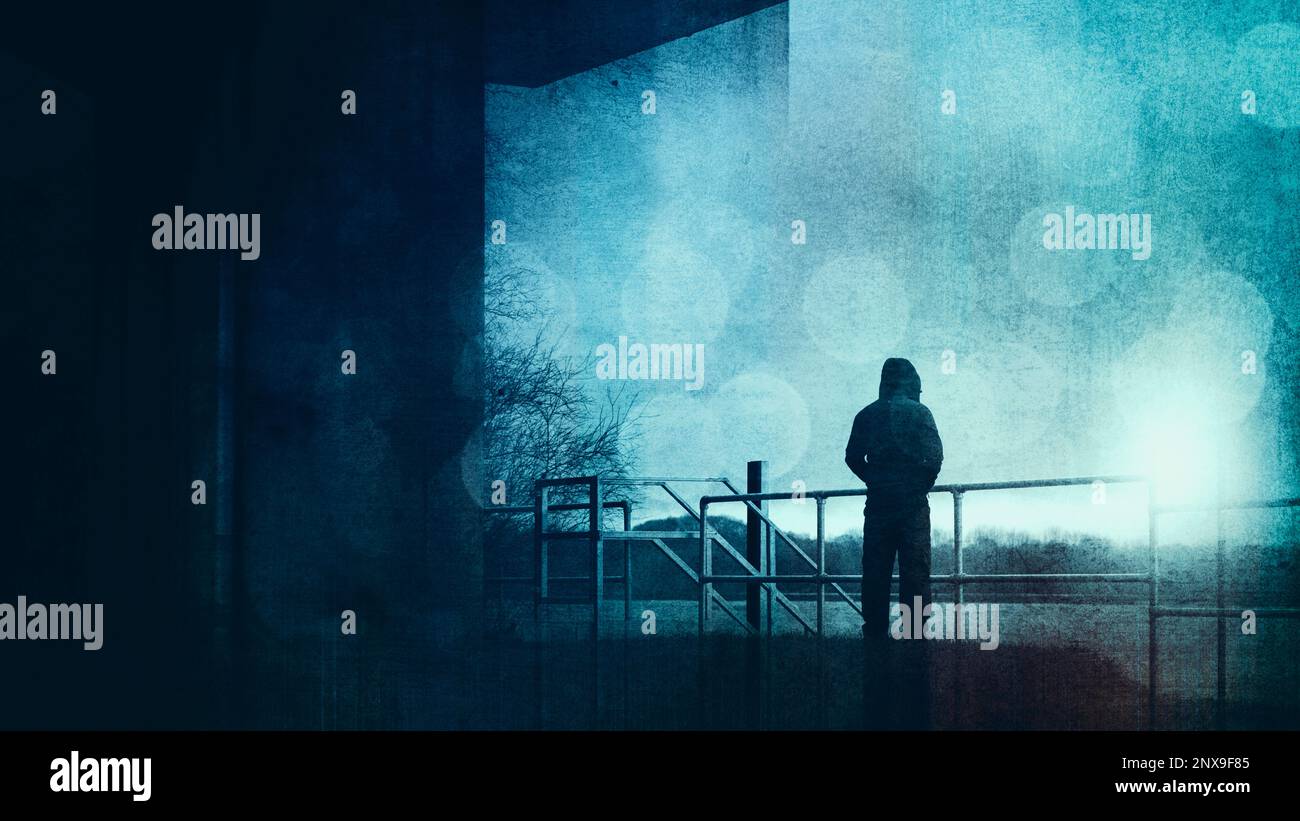 A scary hooded figure looking out, back to camera. Silhouetted against ...