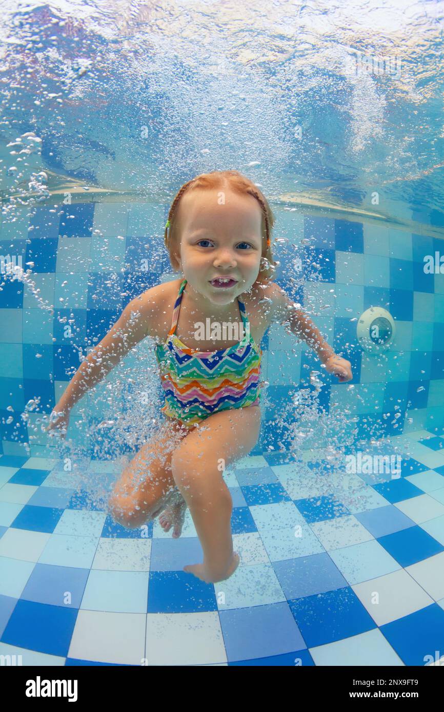 Happy family have fun in swimming pool. Funny child swim, dive in pool ...