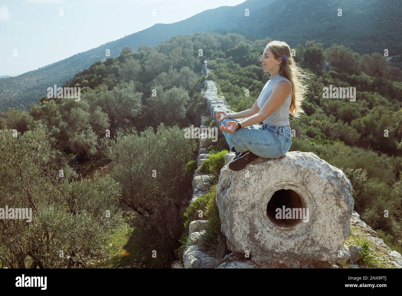 Young woman relax in yoga pose at ruins of old Roman Delikkemer ...