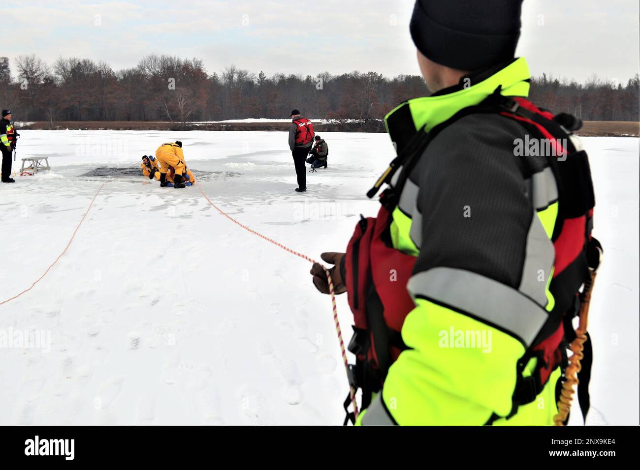 Firefighters wearing cold-water immersion protective suits hold surface ...