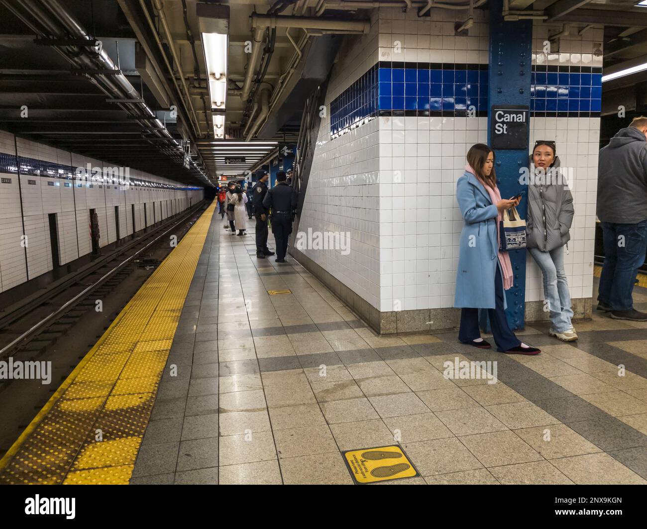Passengers wait for a train at the Canal Street station on the New York ...