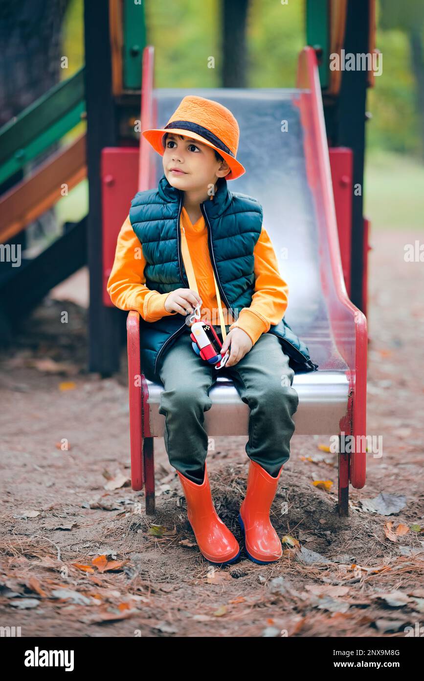 Portrait of a cute boy with an orange hat on the playground Stock Photo ...