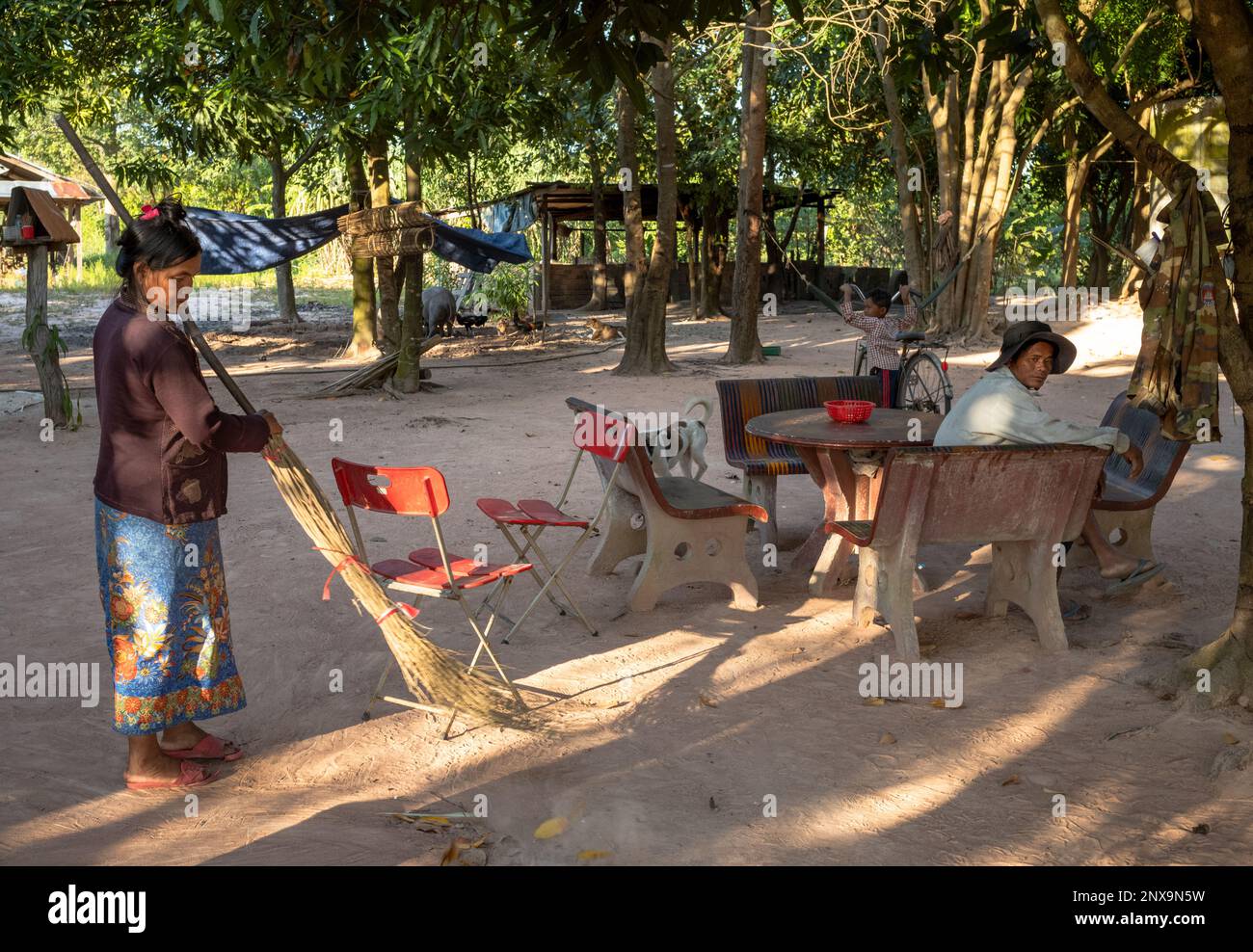 A woman in a rural village in Siem Reap province, Cambodia, sweeps ...