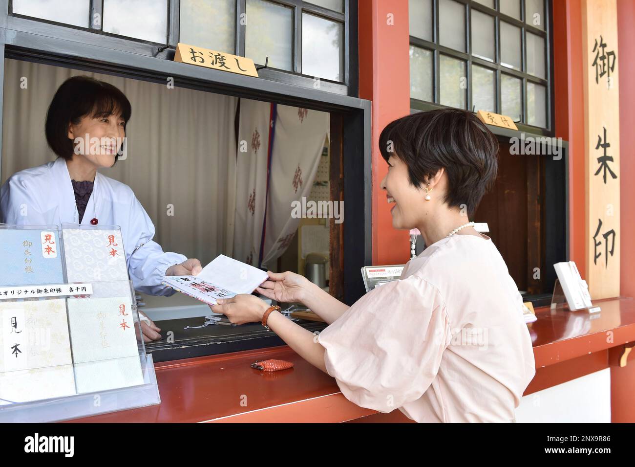 A woman receives Goshuin-cho, a book to collect Goshuin stamp at Hie ...