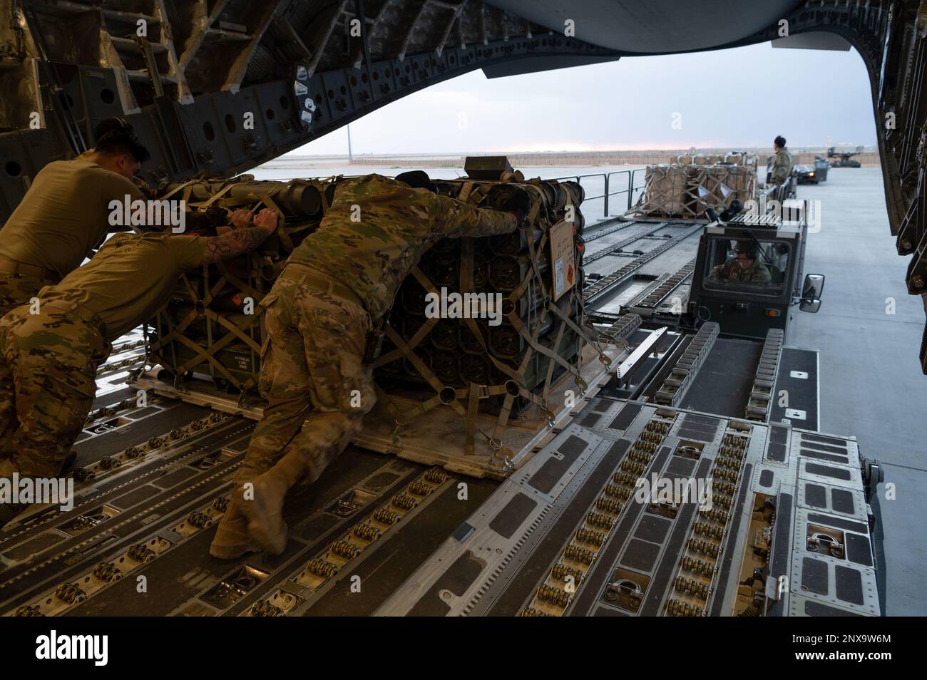 8th Expeditionary Airlift Squadron airmen guide cargo off of a C-17 Globemaster III, at Al Asad ...