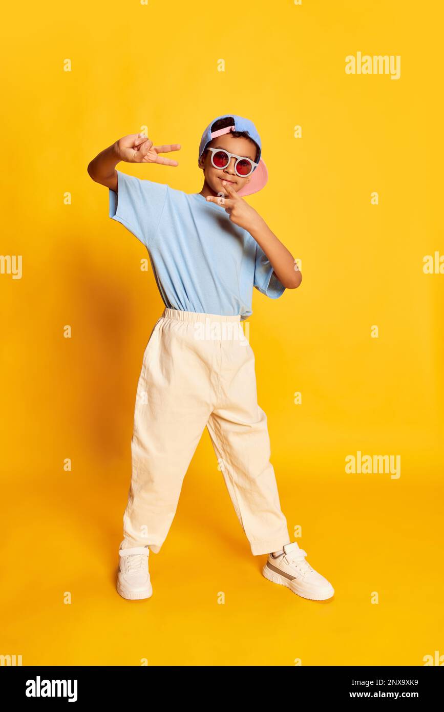 Dynamic portrait of little african boy, hip-hop dancer in stylish ...