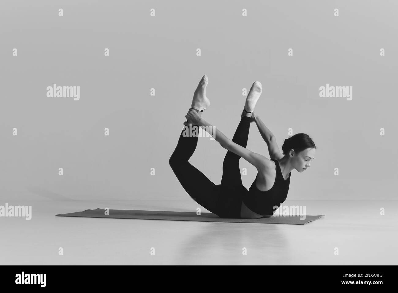 Black and white photography. Young girl with slim fit body training on ...