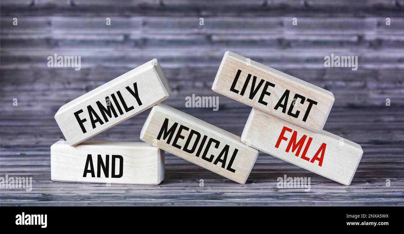 Wooden blocks with text FMLA Family and Medical Live Act on a wooden ...