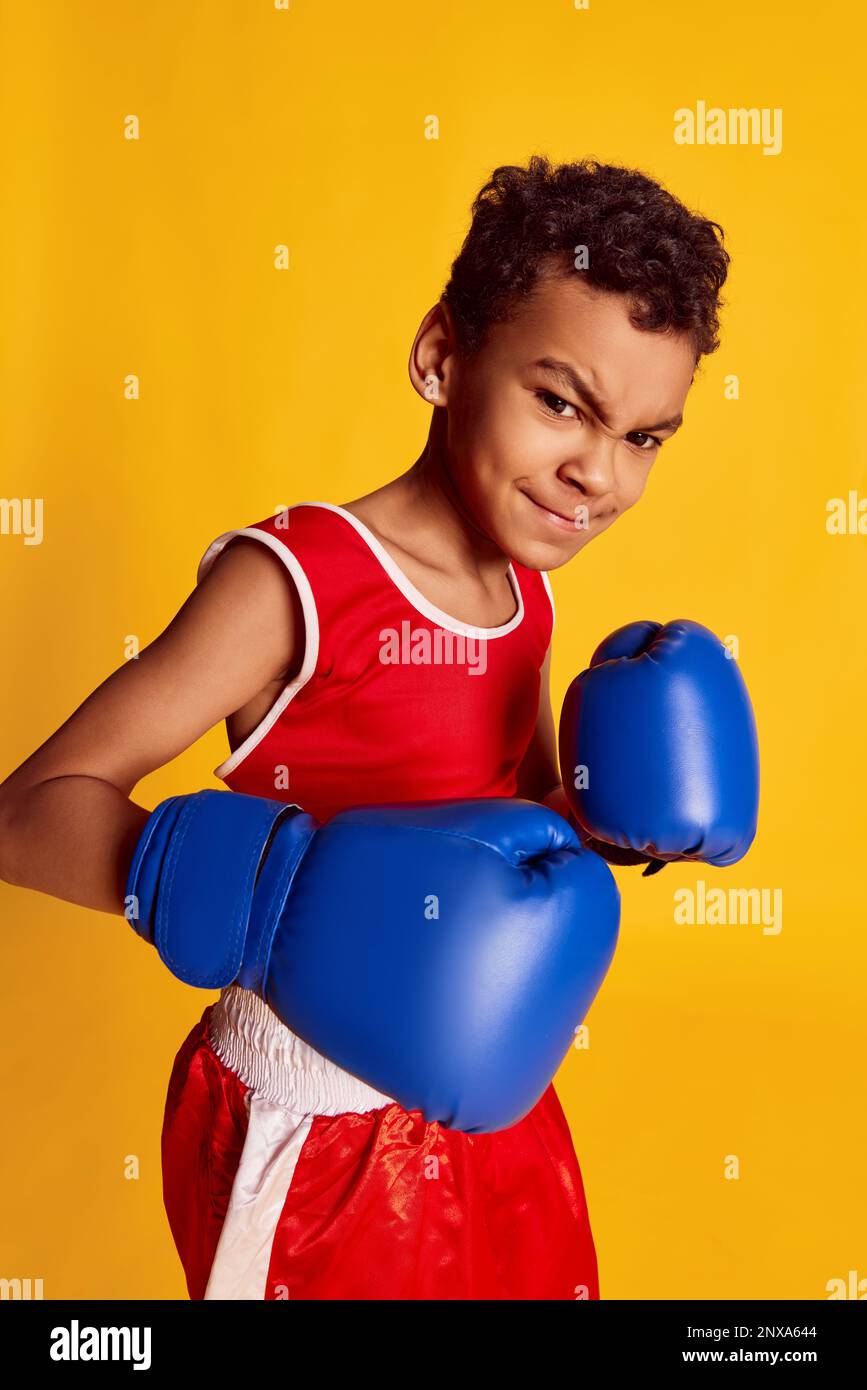 Closeup of sportive little boy, beginner boxer in sports uniform and ...