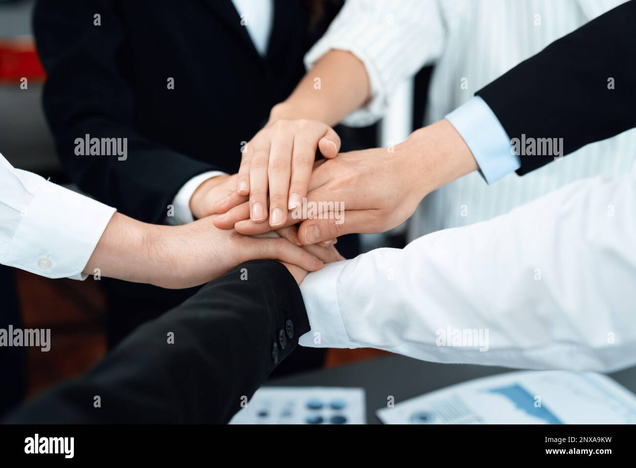 Top view closeup business team of suit-clad businesspeople join hand stack together. Colleague ...