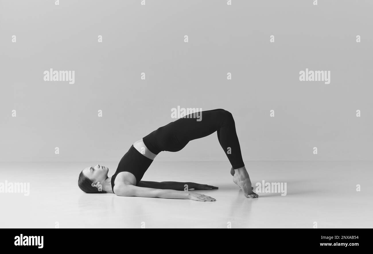 Slim fit body. Black and white photography. Young girl doing stretching ...