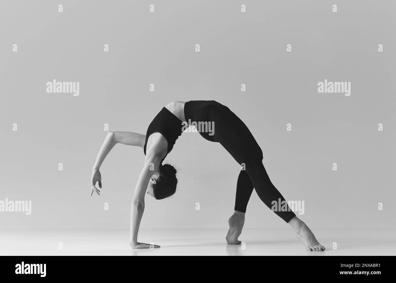 Flexibility and strength. Black and white photography. Young girl doing ...