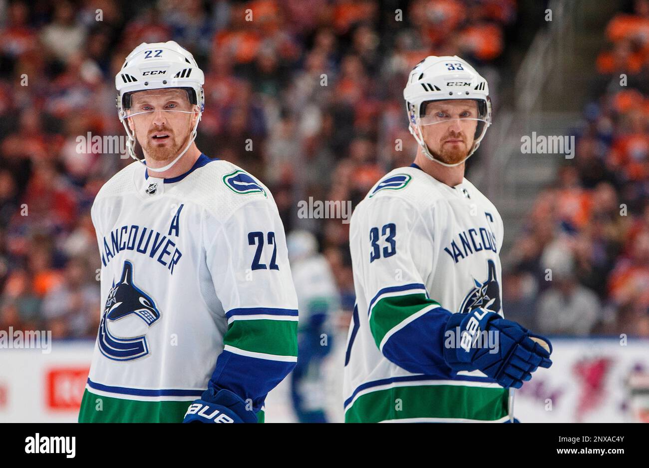 Vancouver Canucks' Daniel Sedin (22) and Henrik Sedin (33) skate past each other during first ...