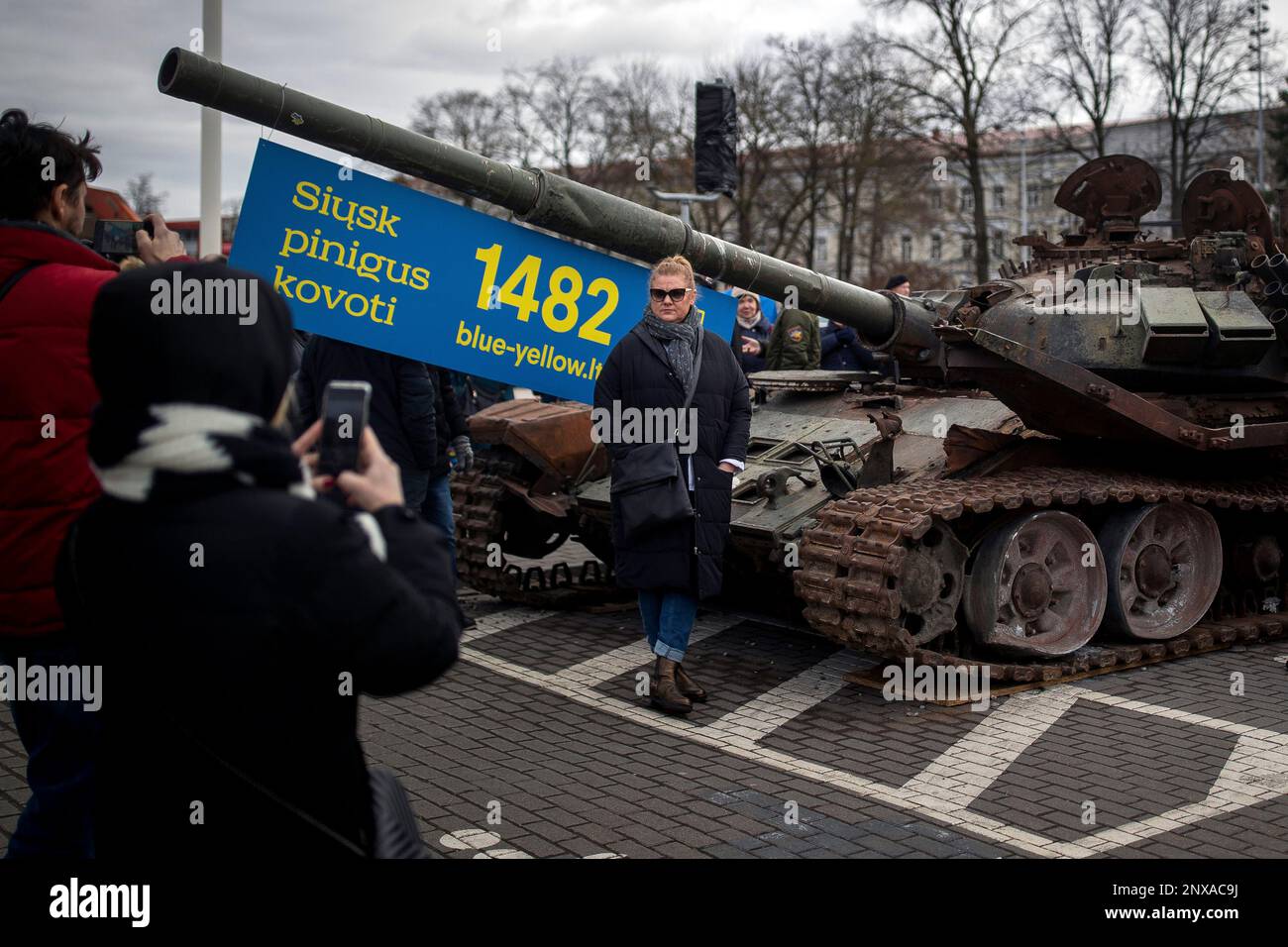 A woman poses for a photo in front of the destroyed Russian tank T-72B ...