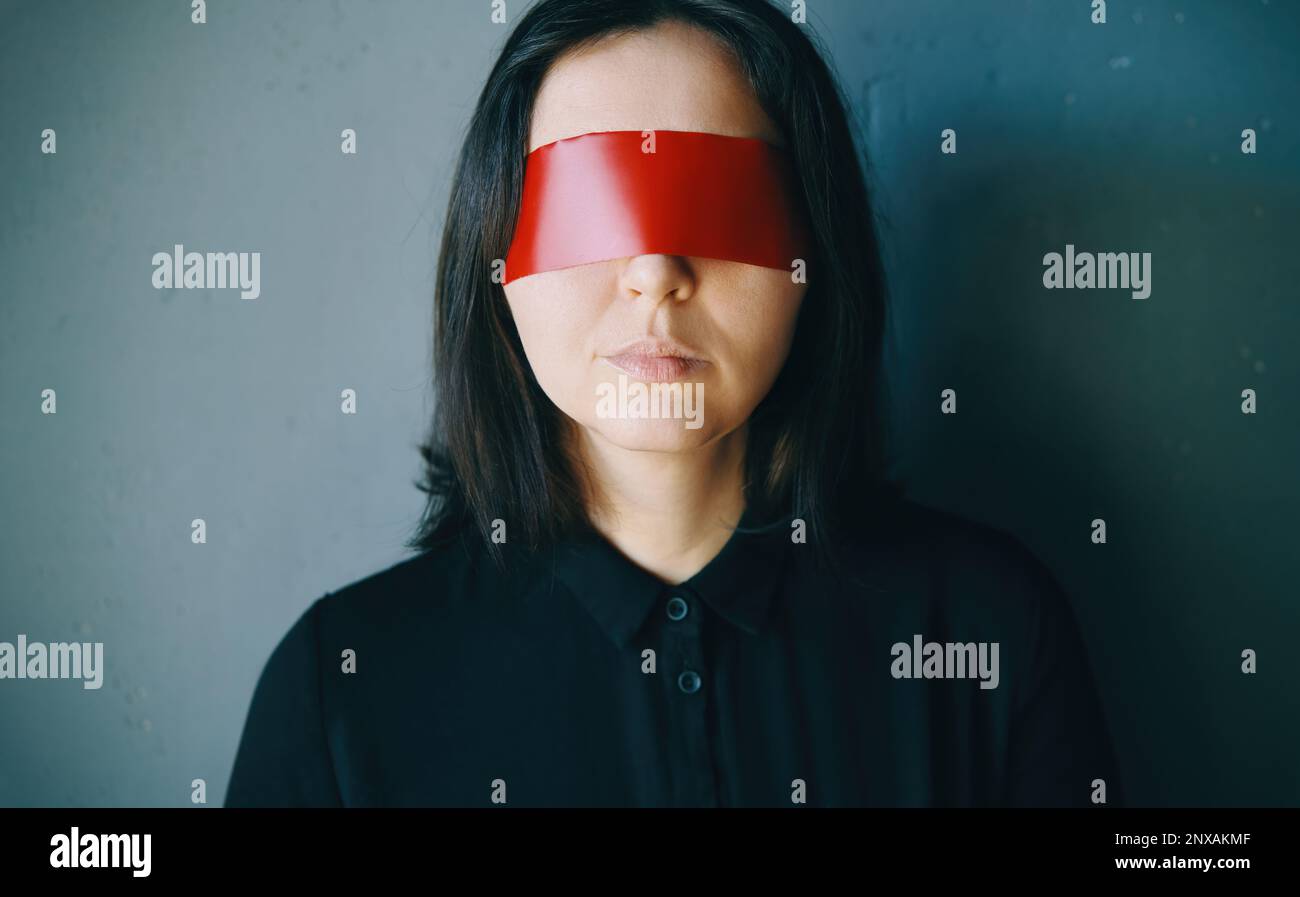Woman with red adhesive tape on the eyes. Ignore concept Stock Photo ...