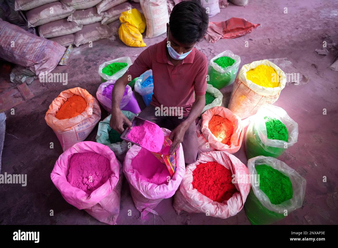 A worker packs natural color powder at factory ahead of Hindu festival ...