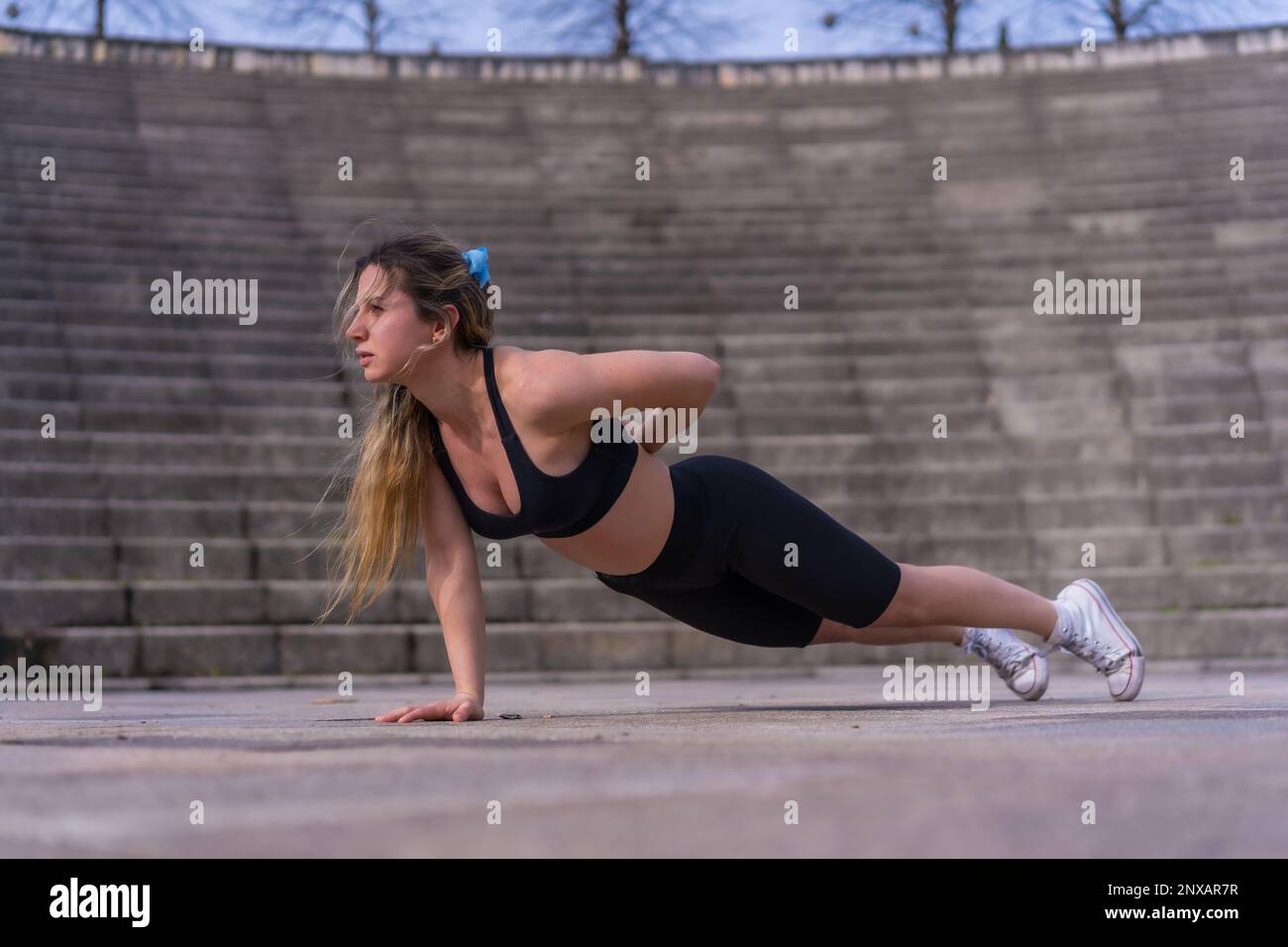 A young caucasian woman doing the push-up exercise with one arm Stock ...