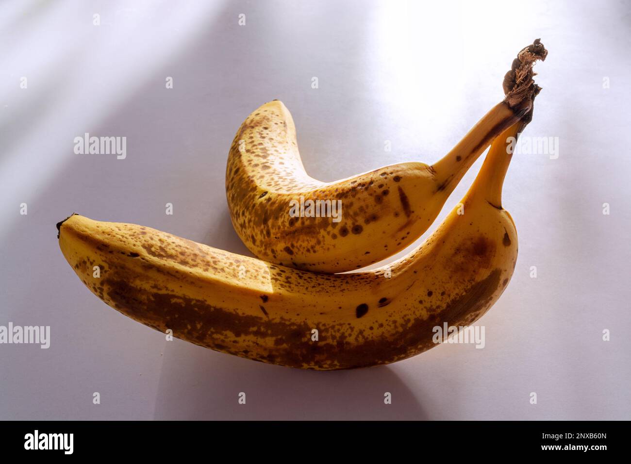 Two ripe bananas on white table close-up in interesting composition 3 ...
