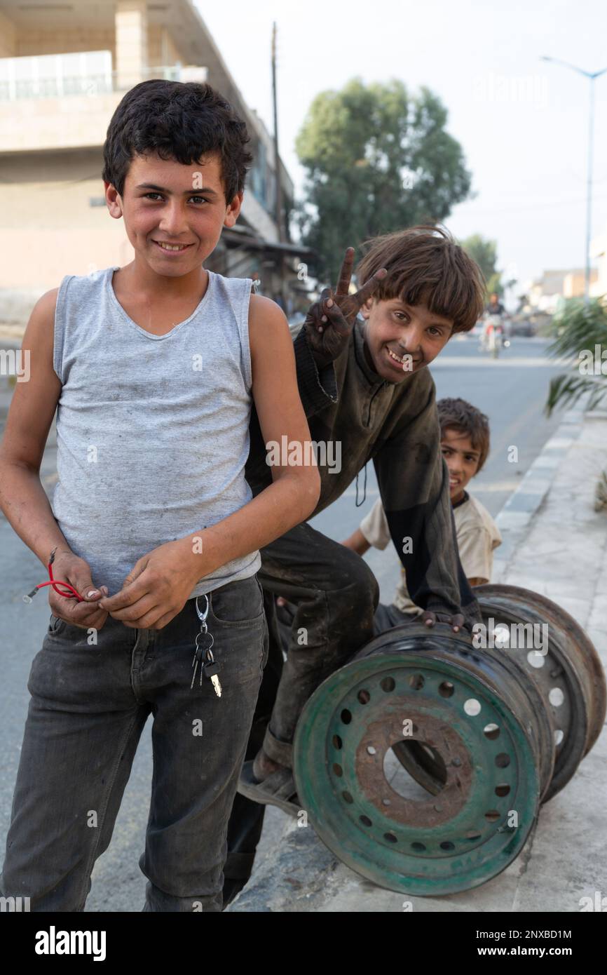 Selective focus on Syrian child workers at auto repair shop. Children ...