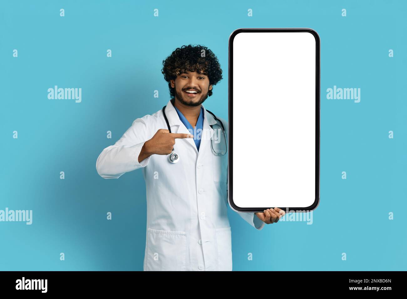 Handsome eastern man doctor hodling big smartphone, mockup Stock Photo ...