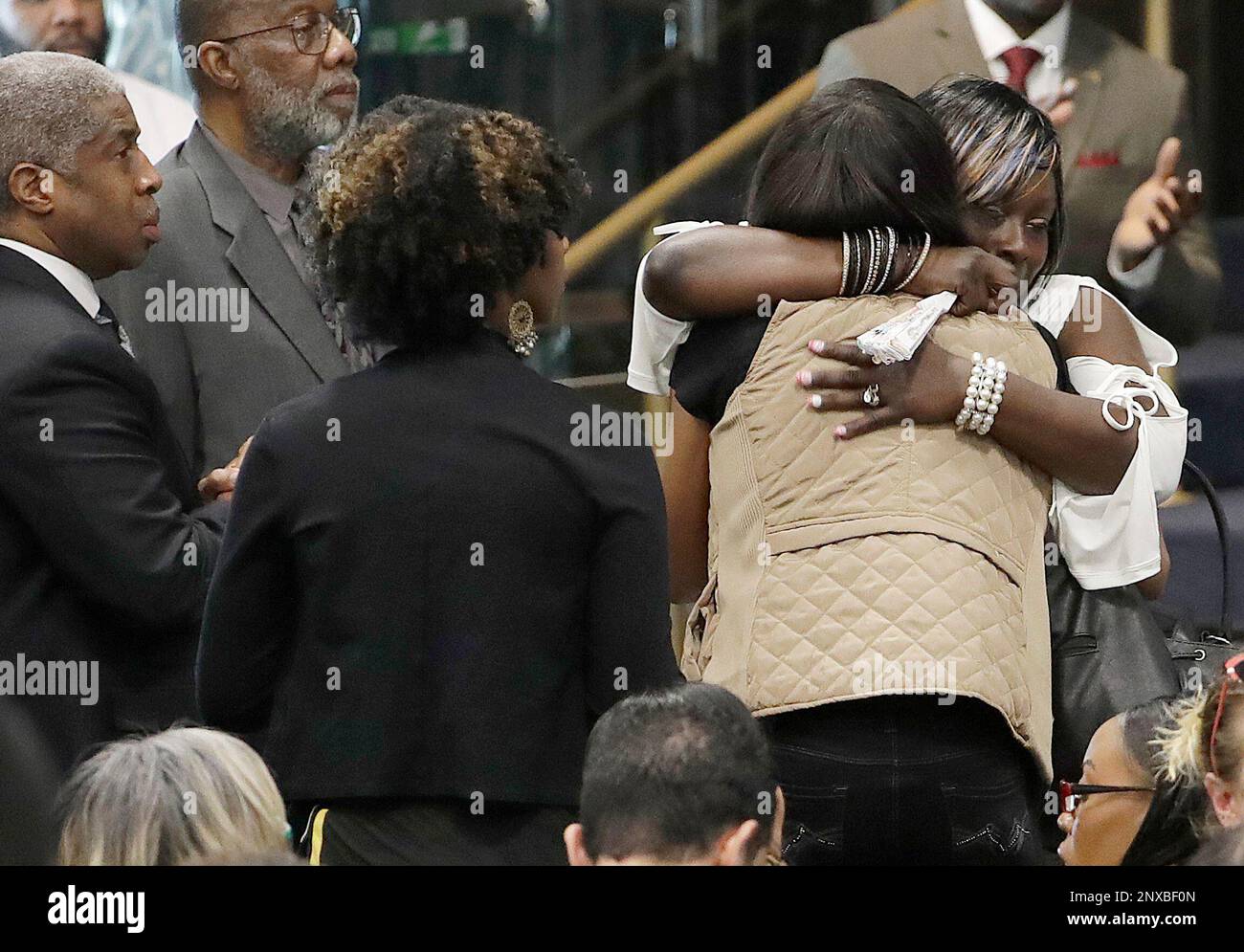Mourners embrace during the funeral services for police shooting victim ...