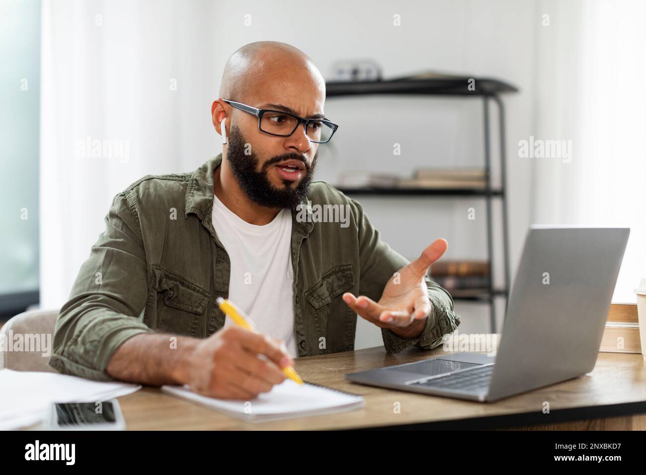 Angry emotional businessman having video call with employees and taking ...