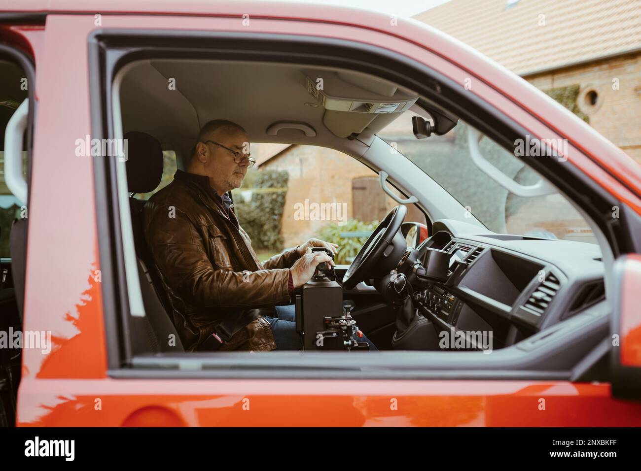 Retired senior man with disability sitting inside van Stock Photo - Alamy